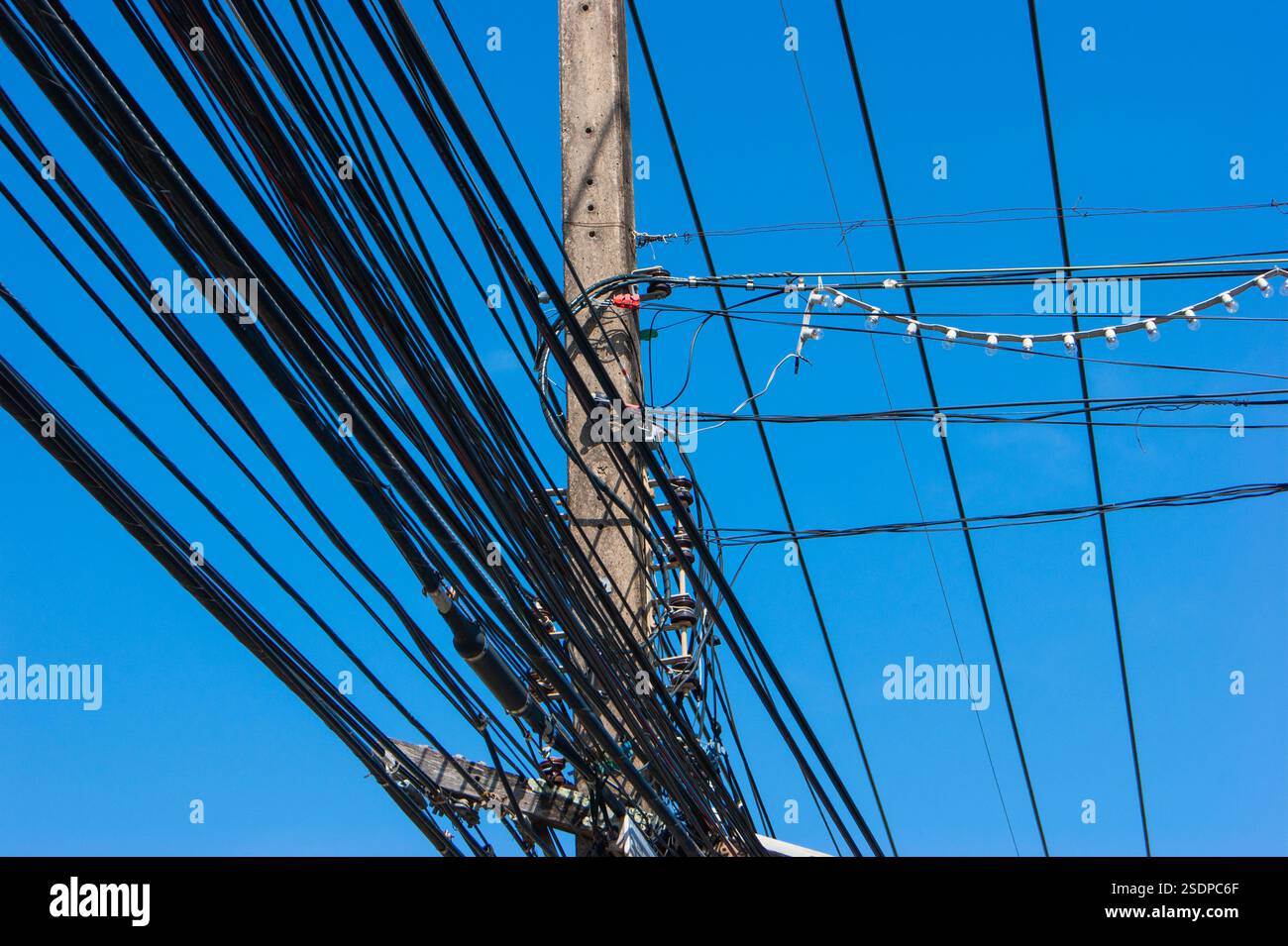 Intertwining of many electrical wires on poles Stock Photo - Alamy