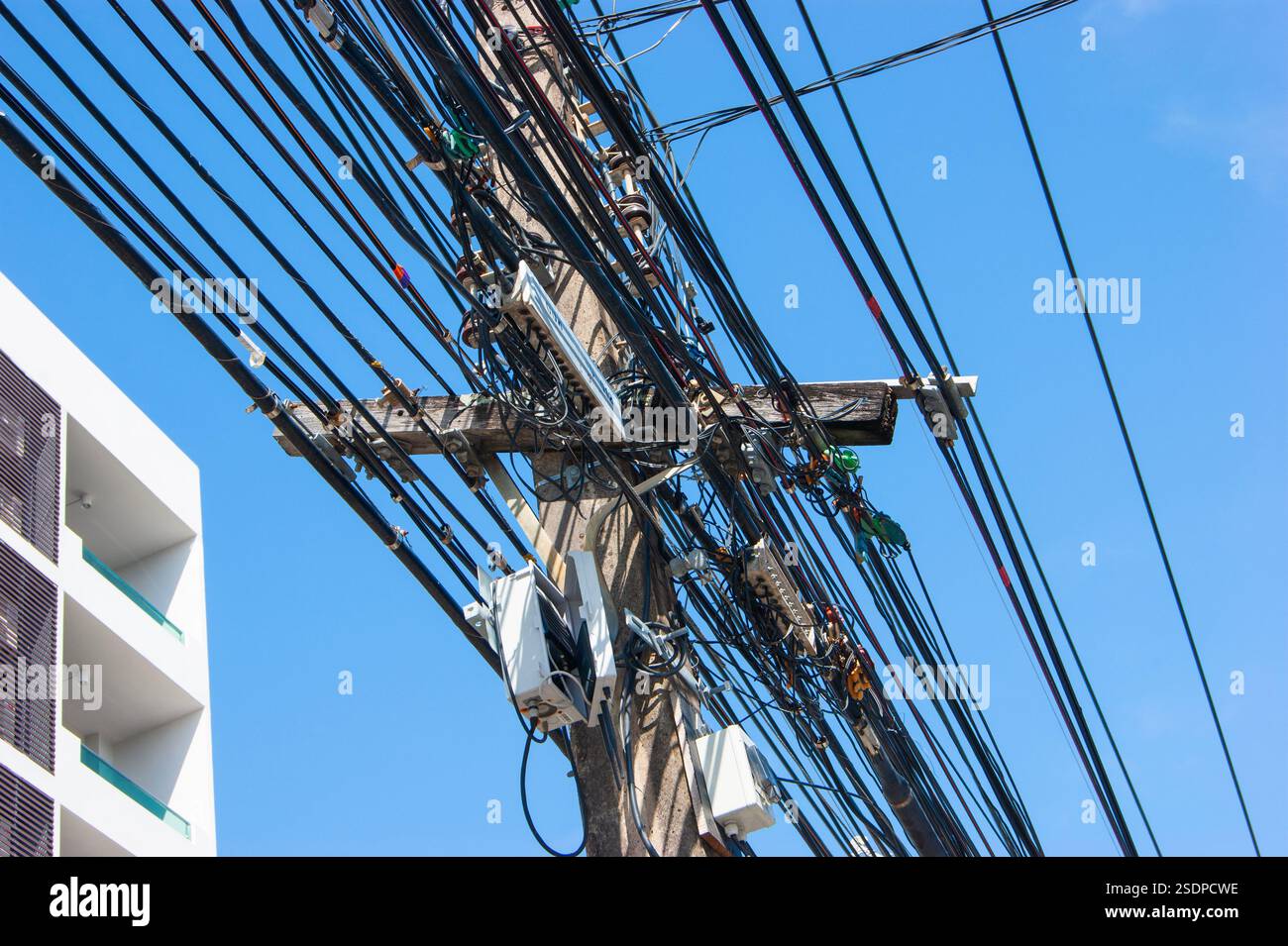 Intertwining of many electrical wires on poles Stock Photo - Alamy