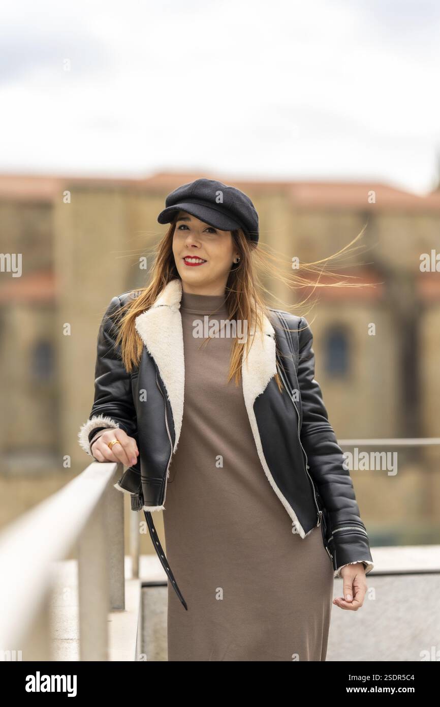 Portrait of a fashionable woman posing in a city environment, wearing a ...