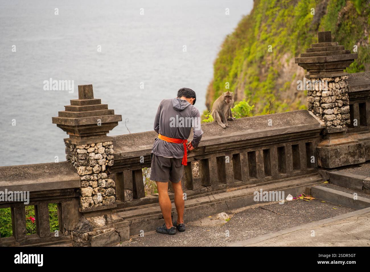 Bali, Indonesia - November 30, 2023: Tourist in gray attire observes a ...