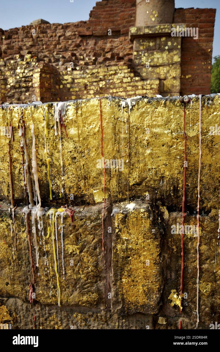 Melted candle wax and gold leaves pasted on wall of shrine of ruined ...