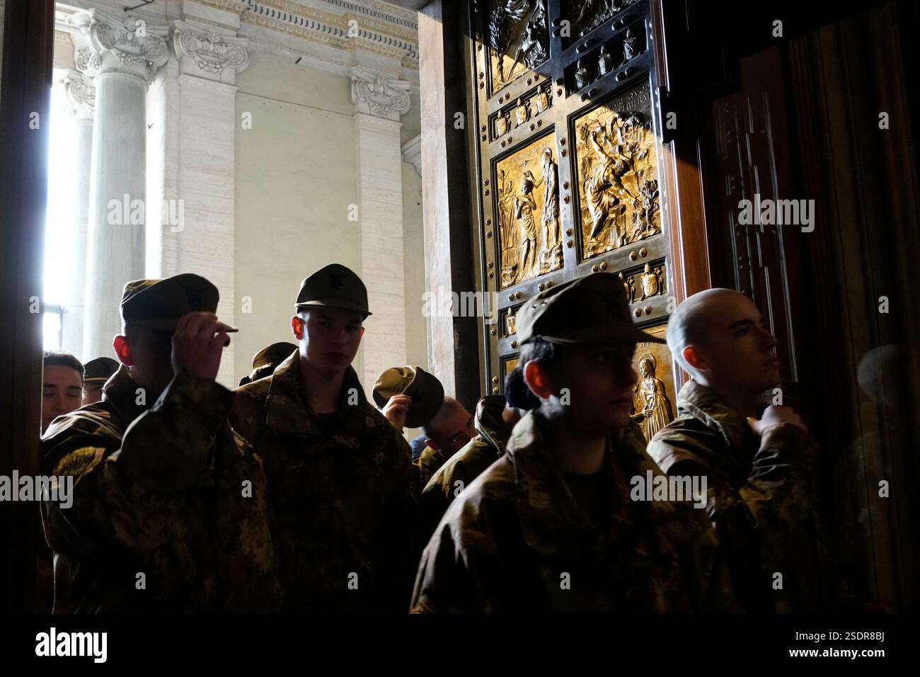 Members of the military walk through St. Peter Basilica's holy door, on ...