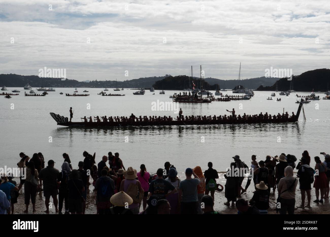 Waka Taua (war canoes) pass spectators on the beach, during Waitangi ...