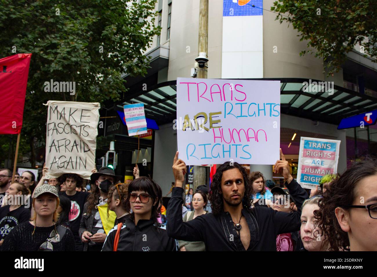 Protesters hold signs saying 'Trans rights are human rights' and 'make ...
