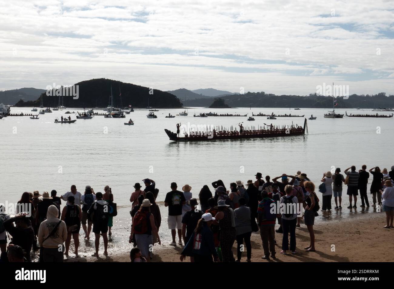 Waka Taua (war canoes) pass spectators on the beach, during Waitangi ...