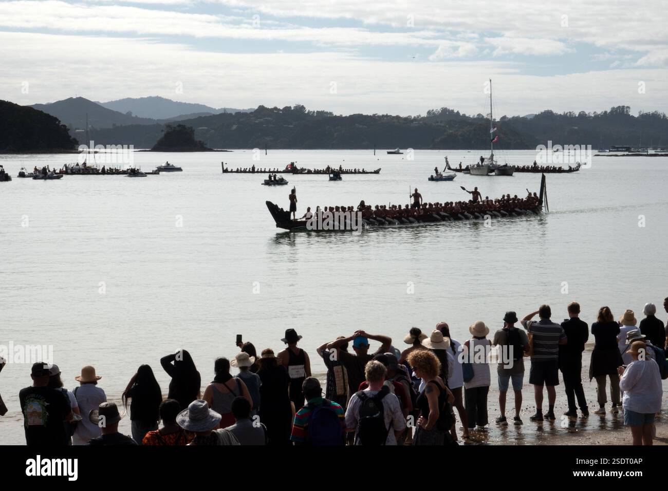 Waka Taua (war canoes) pass spectators on the beach, during Waitangi ...