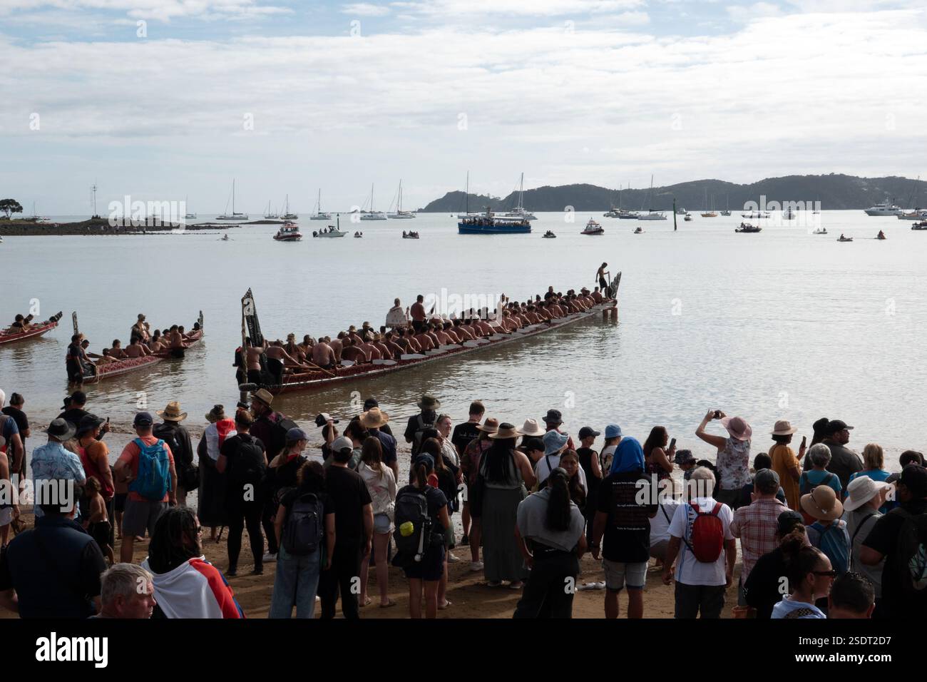 Traditional Maori waka canoe leaving the beach during Waitangi Day ...