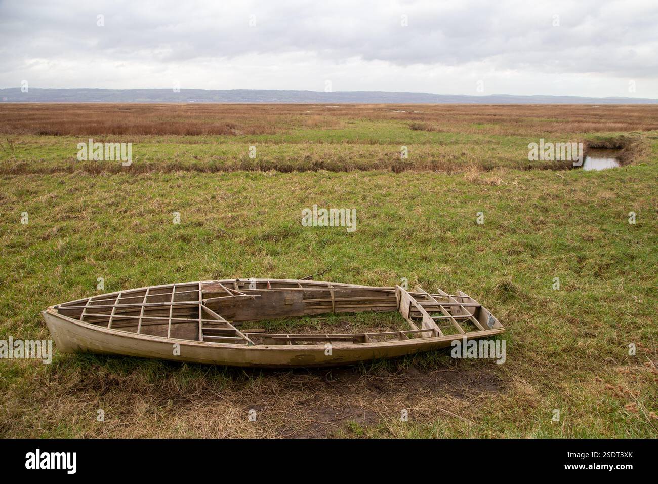 The remains of an abandoned fishing boat washed up on the salt marshes ...
