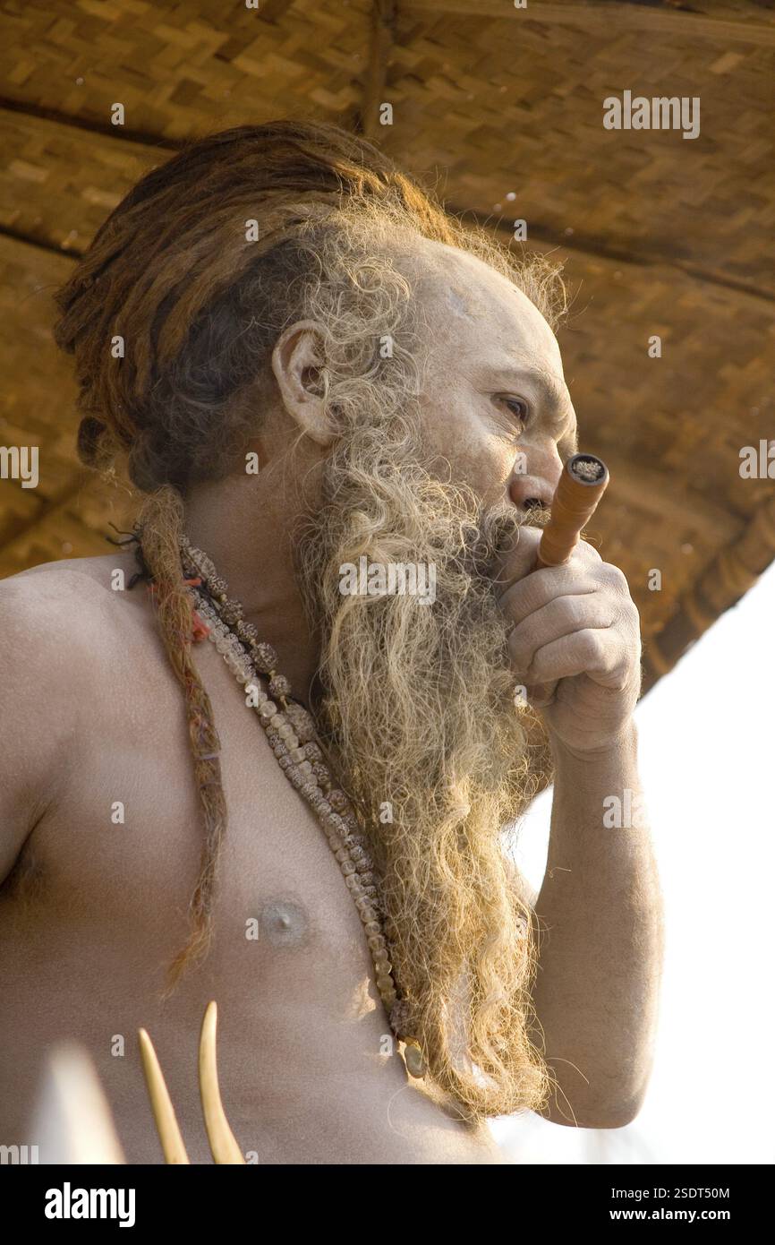 Hindu saint naga baba Shivdasgiri smoking tobacco in Varanasi on Ganga ...