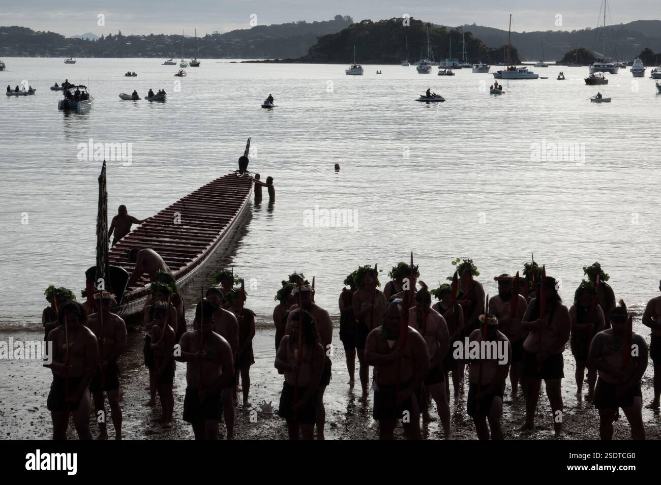 Traditional Maori waka and people on beach during Waitangi Day ...