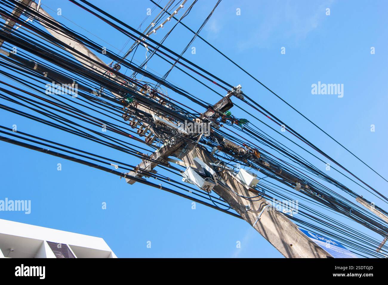Intertwining of many electrical wires on poles Stock Photo - Alamy