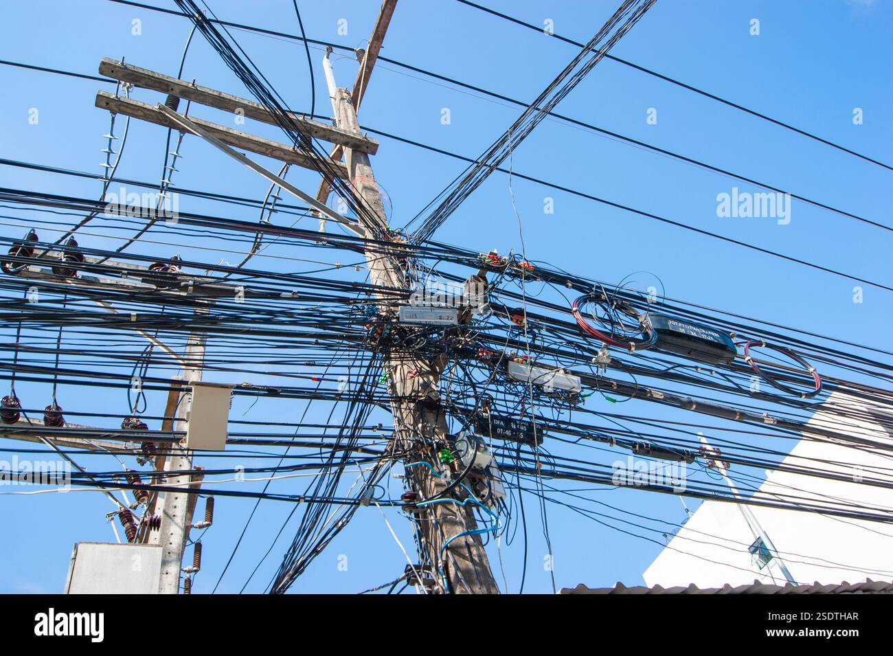 Intertwining of many electrical wires on poles Stock Photo - Alamy