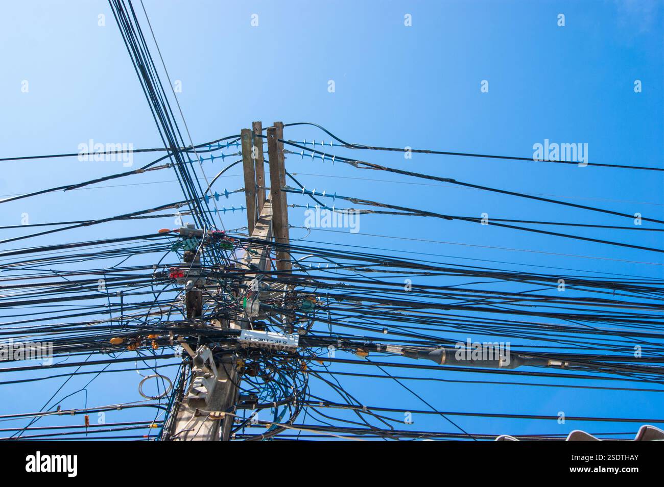 Intertwining of many electrical wires on poles Stock Photo - Alamy