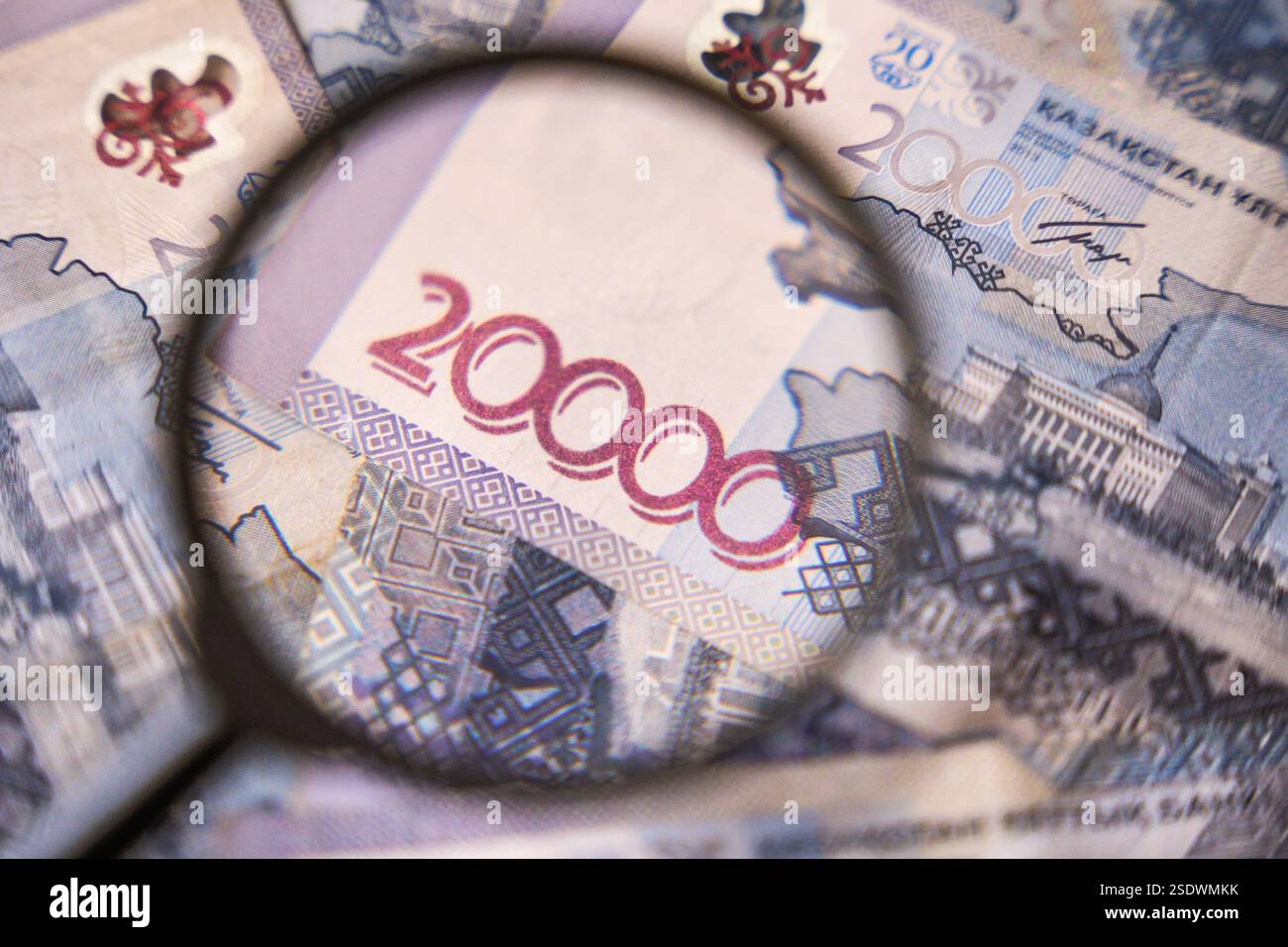 Part of a blurred 20,000 tenge banknote through a magnifying glass ...