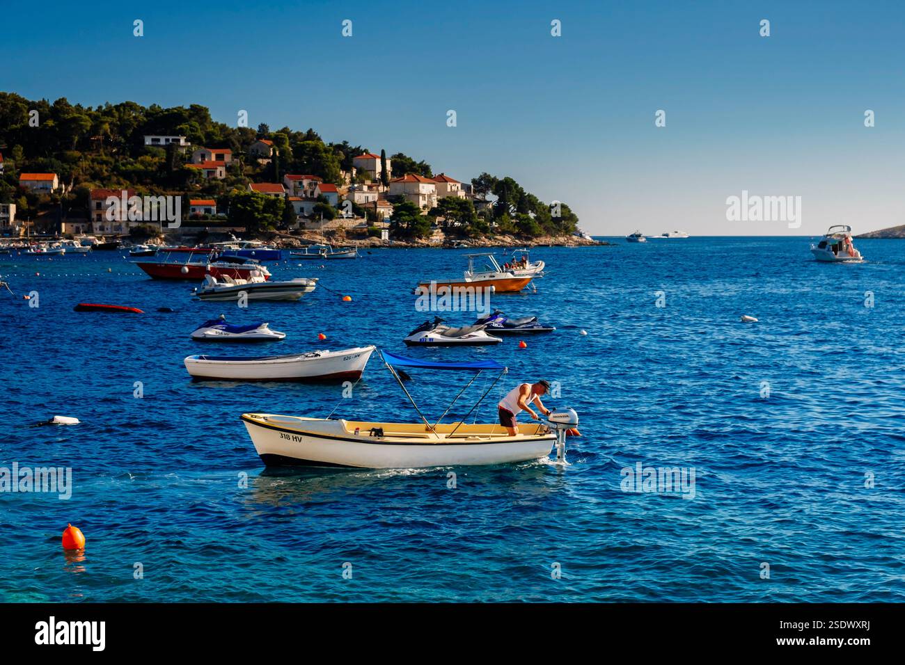 Man starting small boat/ dingy at Krishna Luka beach, Hvar, Island of ...
