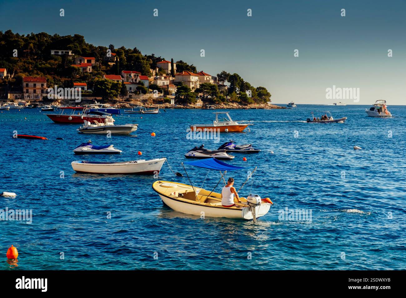 Man driving small boat/ dingy at Krishna Luka beach, Hvar, Island of ...