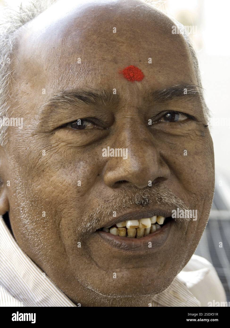 Old Indian man with red tilak on forehead looking at camera, Model ...