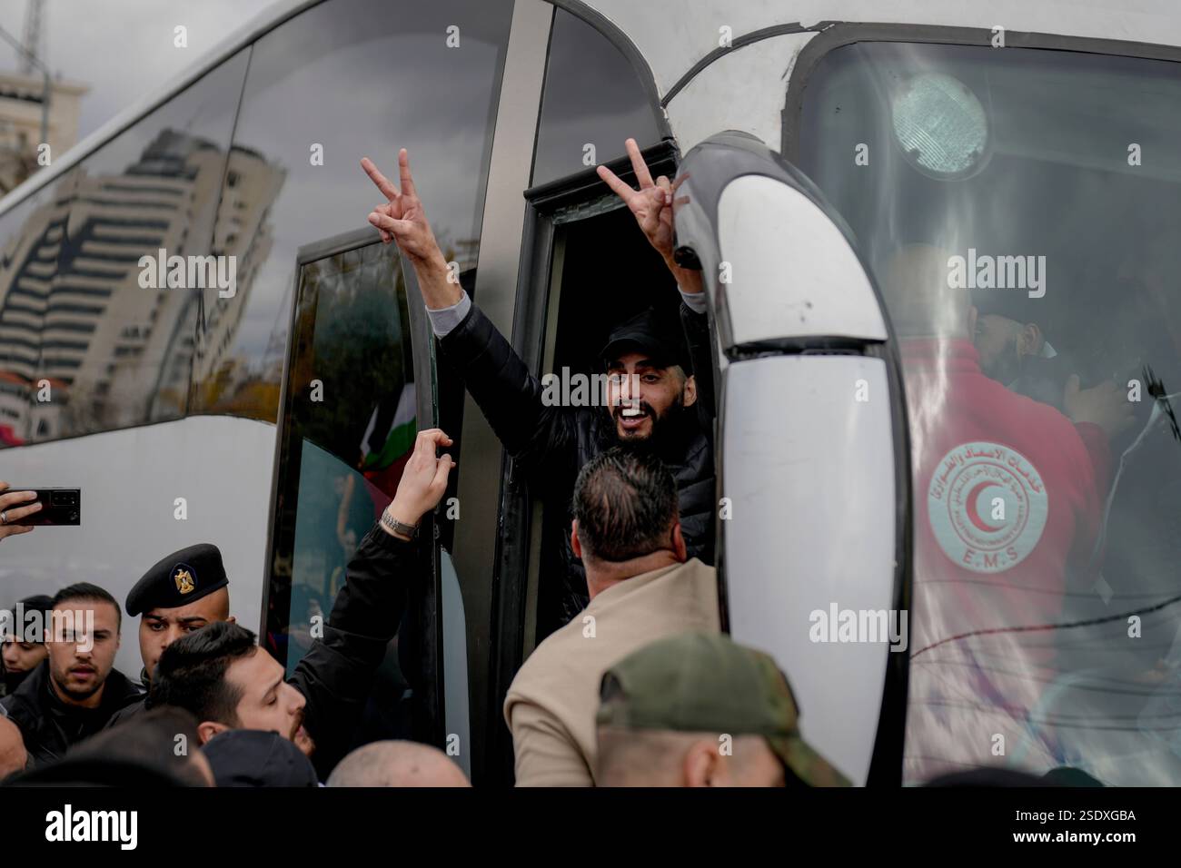 A Palestinian prisoner flashes a V sign as he exits a Red Cross bus ...