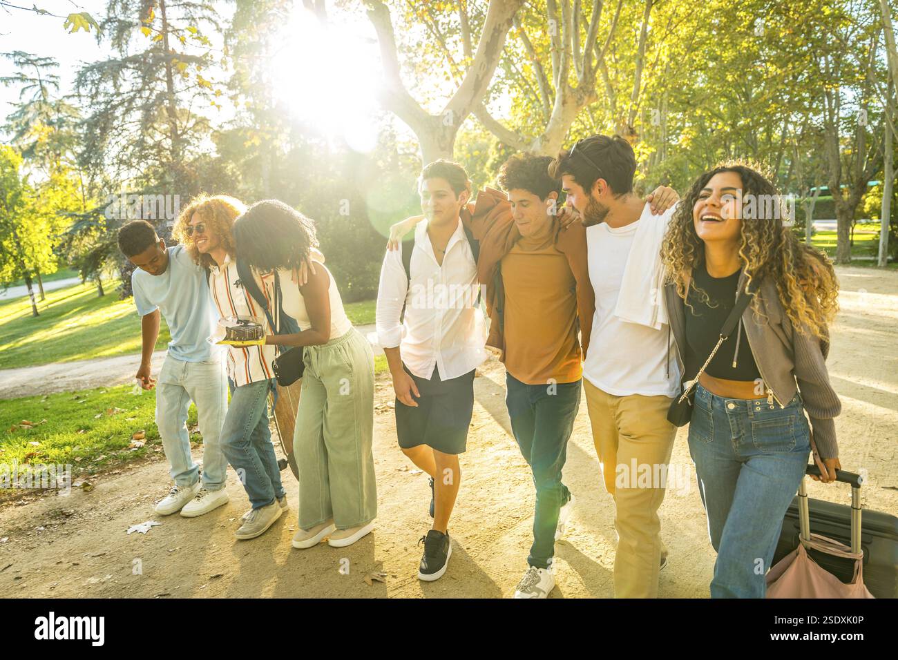 Multiracial young students walking together embracing from the back ...