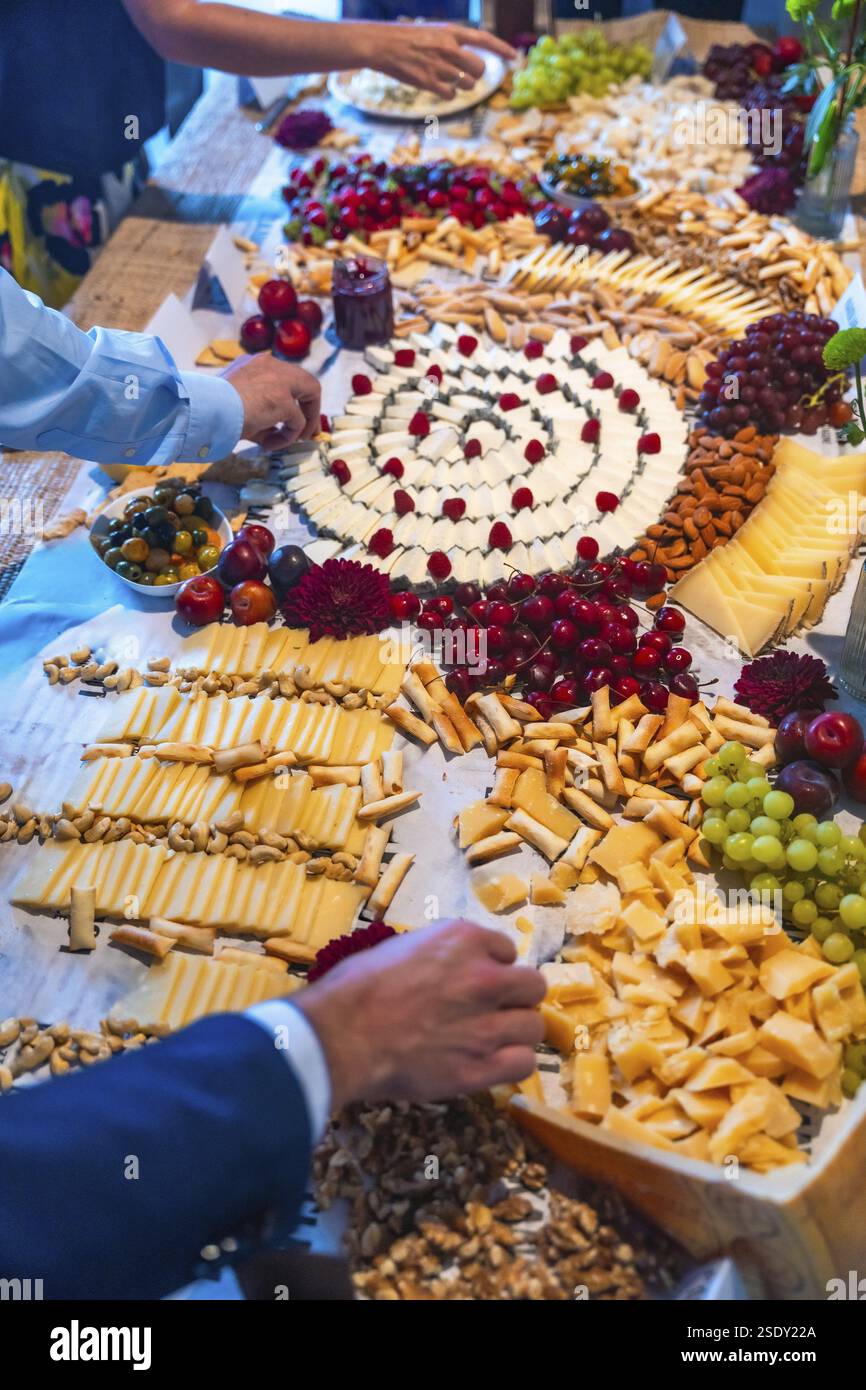 Wedding guests selecting food from a buffet table richly decorated with ...