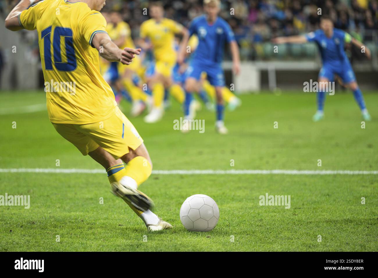 Soccer ball and legs of player during football match Stock Photo - Alamy
