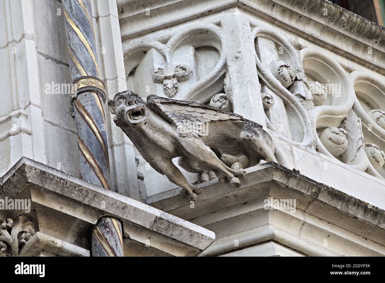 A stone gargoyle with dramatic features is positioned on a building in ...