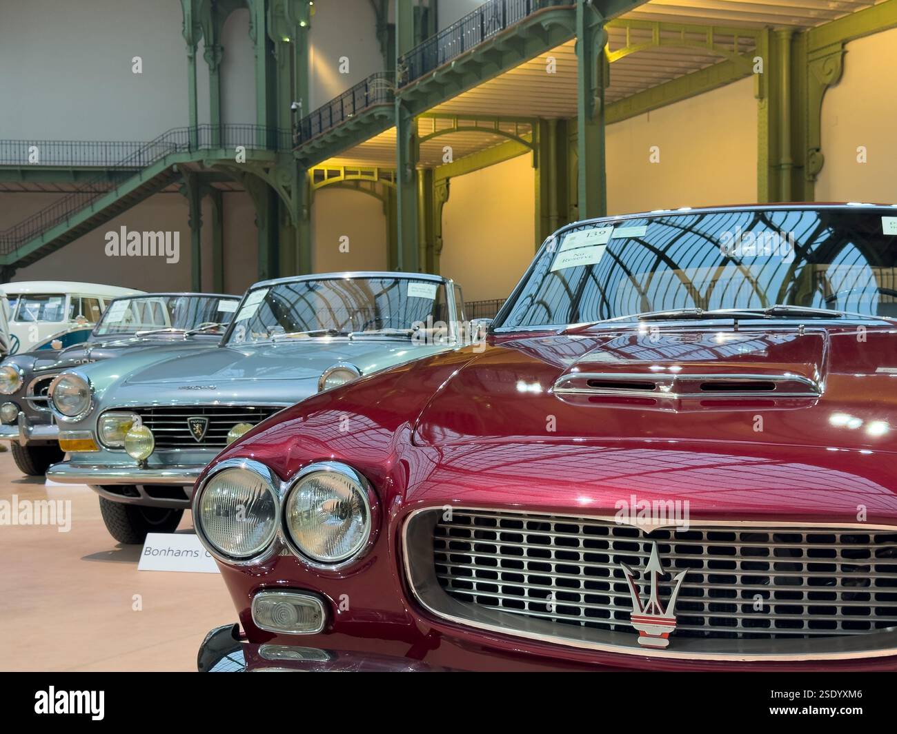Classic automobiles showcased in a grand exhibition hall filled with ...