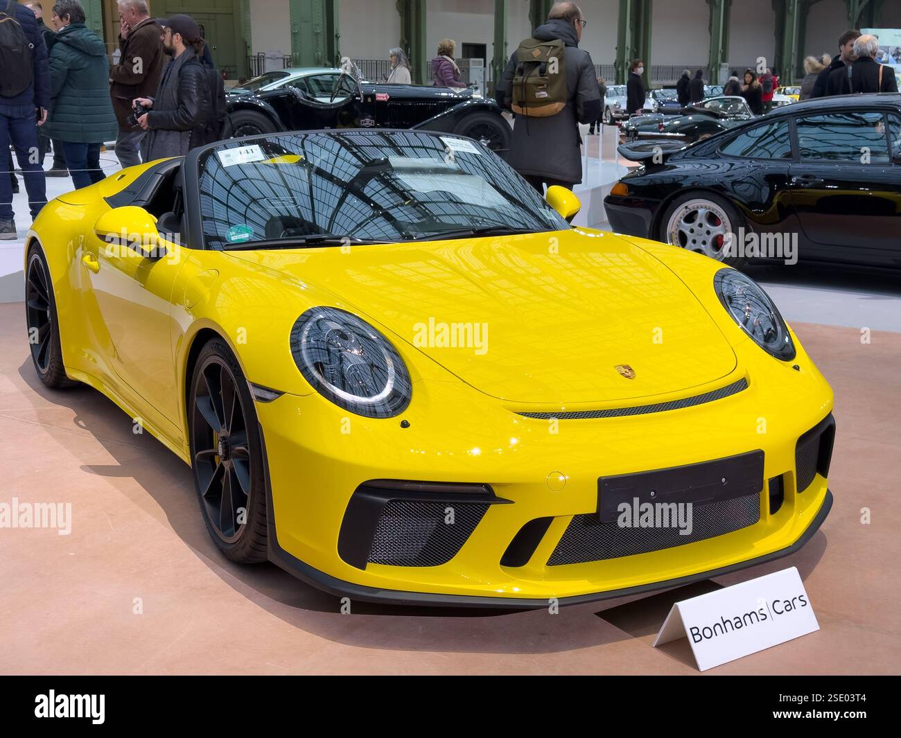 Bright yellow sports car showcased at a classic vehicle exhibition ...