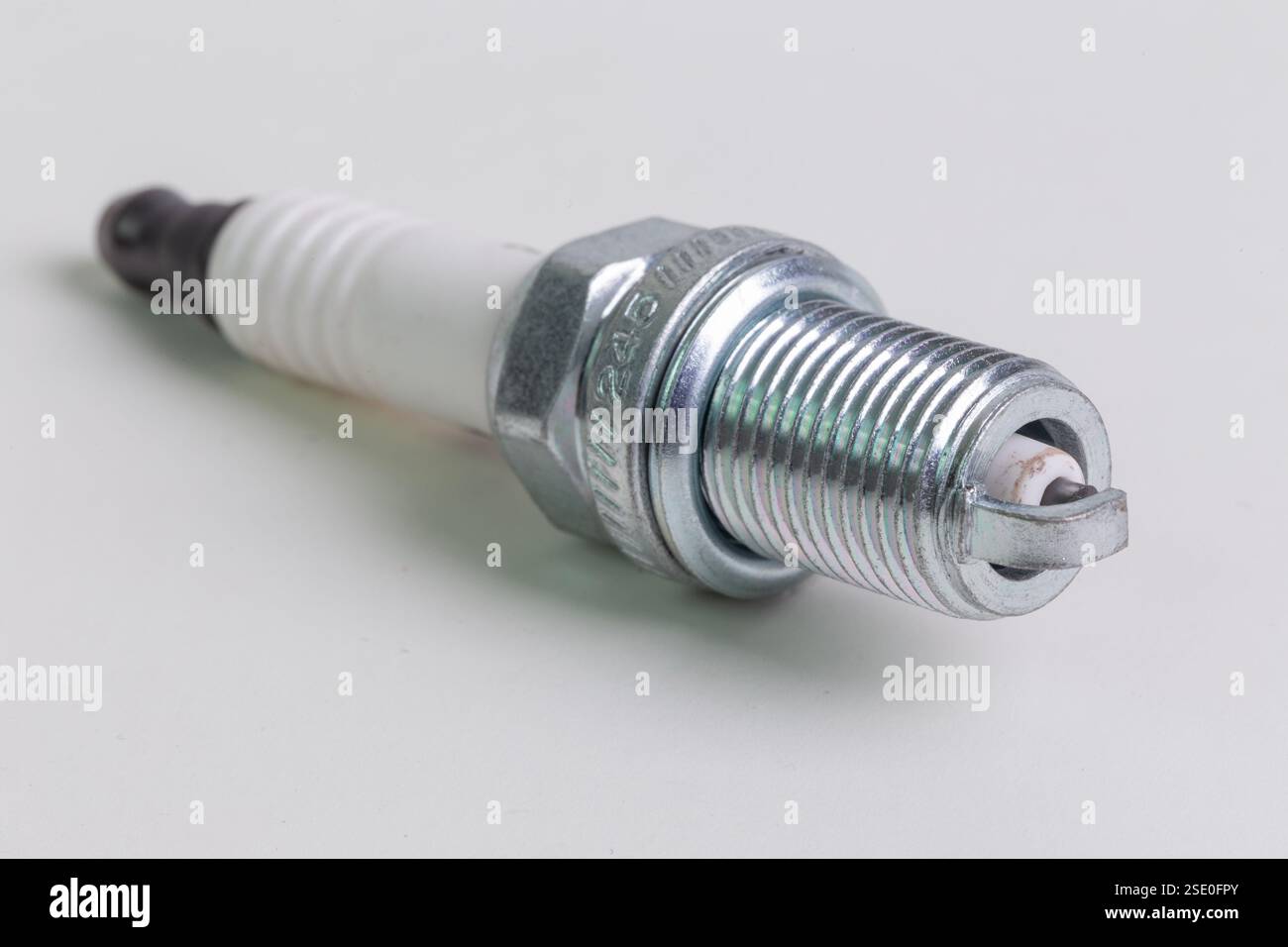 The sparking plug on a white background Stock Photo - Alamy