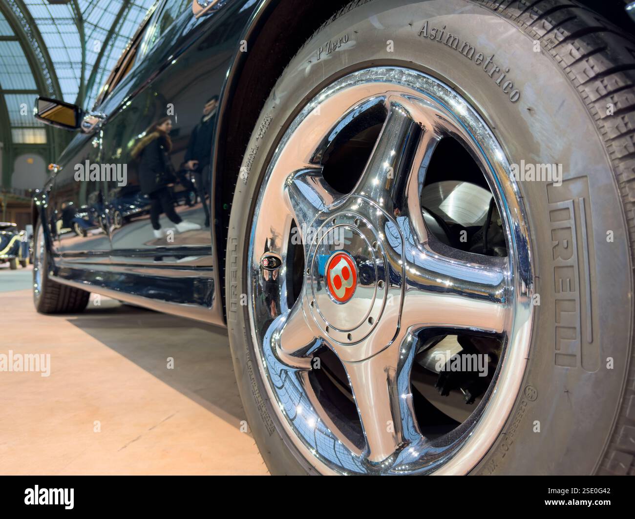 Stunning chrome wheel of an elegant luxury automobile showcased indoors ...