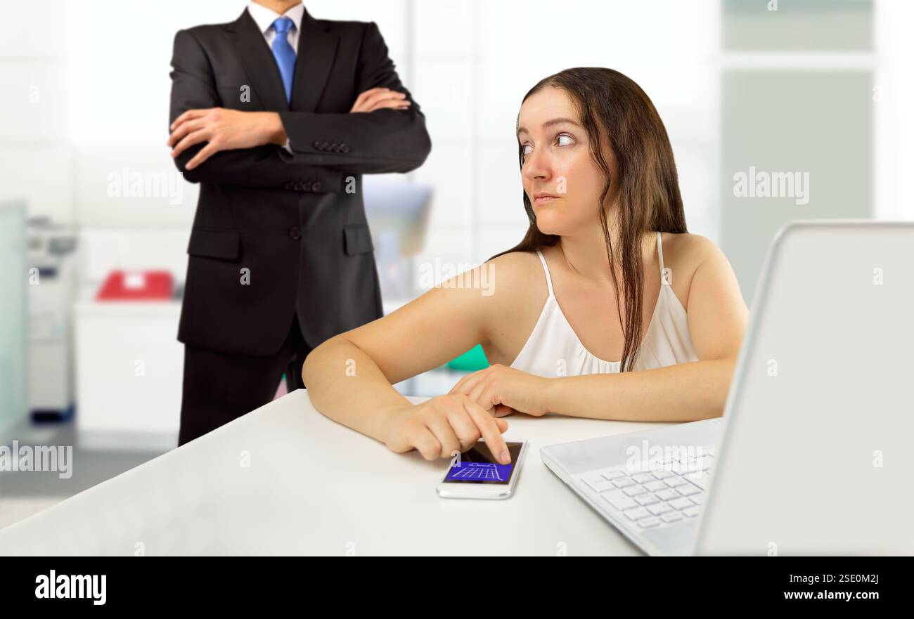 Lazy female employee playing games with her smartphone sitting in a ...