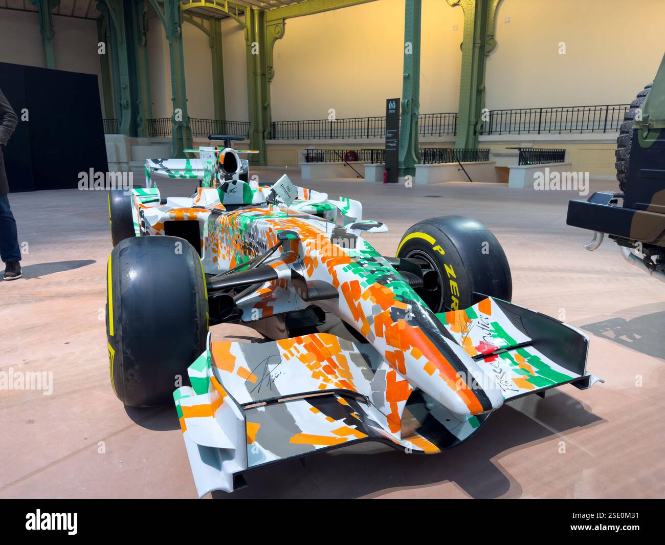 Racing car displayed in vibrant colors at a modern exhibition venue ...