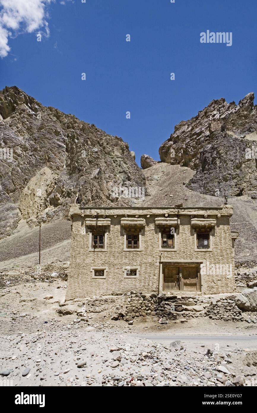 Traditional mud and wood double floor house camouflaged in barren ...