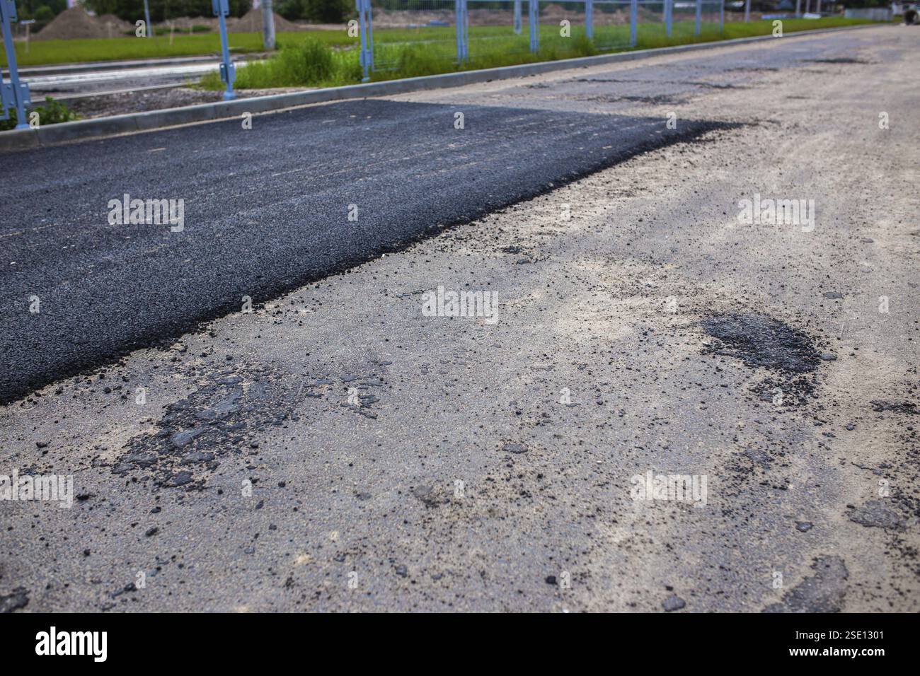 Patchy and uneven asphalt surface extending along a rural road Stock ...