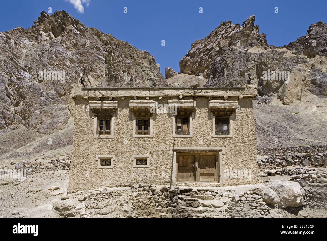 Traditional mud and wood double floor house camouflaged in barren ...