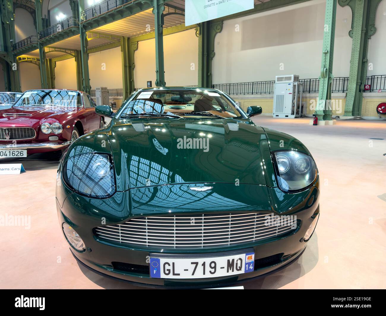 Elegant green sports car displayed indoors at a classic car exhibition ...