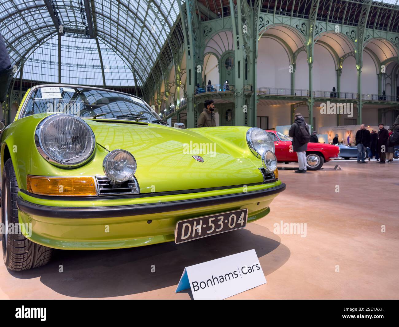 Vibrant classic car showcased in elegant exhibition hall with expansive ...