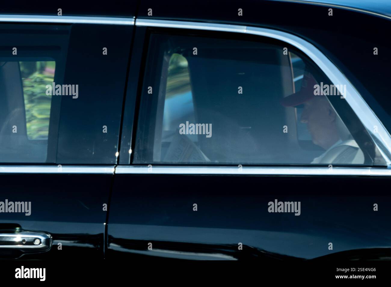 President Donald Trump reads a newspaper as he travels to his golf ...