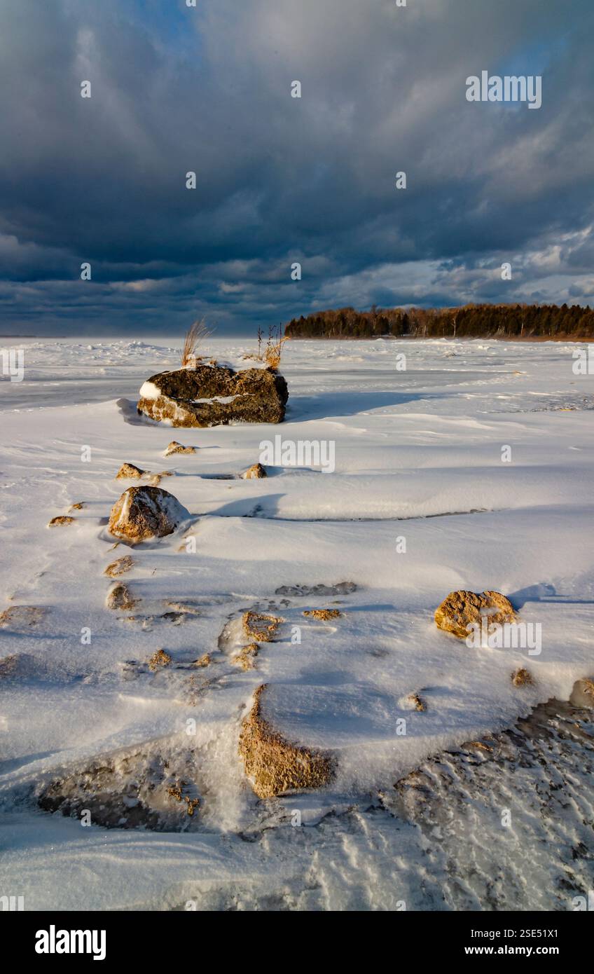 Stone peek out of the ice and snow just off the shore in Peninsula ...