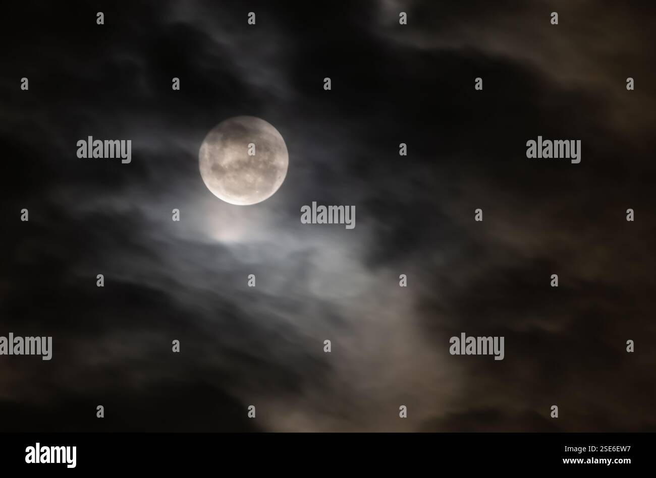 Full moon in dark night. Moonlight between the clouds. Dramatic clouds with the moonlight. Long ...