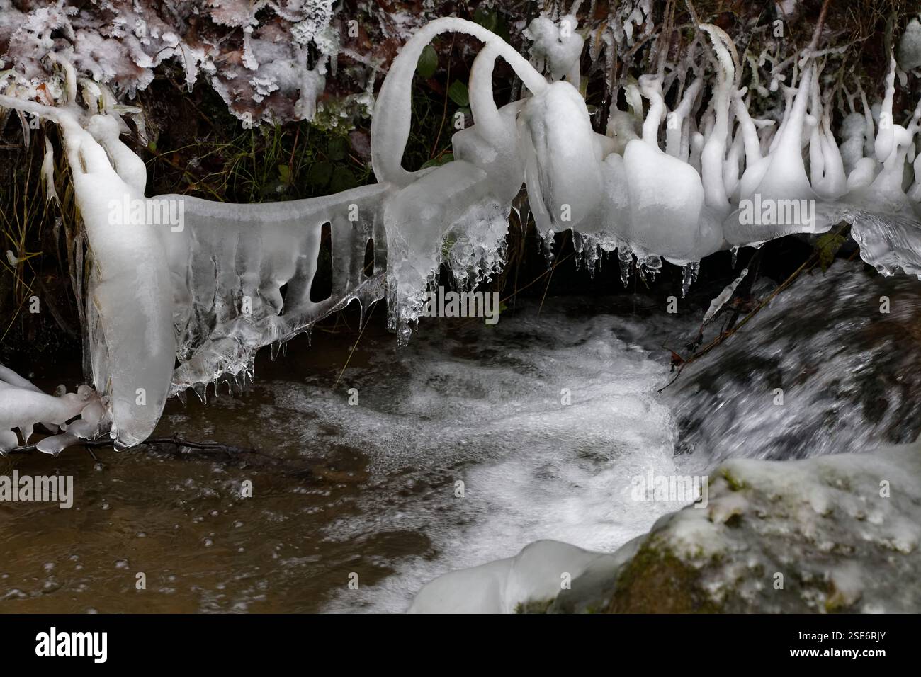 Hanging ice sculptures above a little creek that have formed during ...