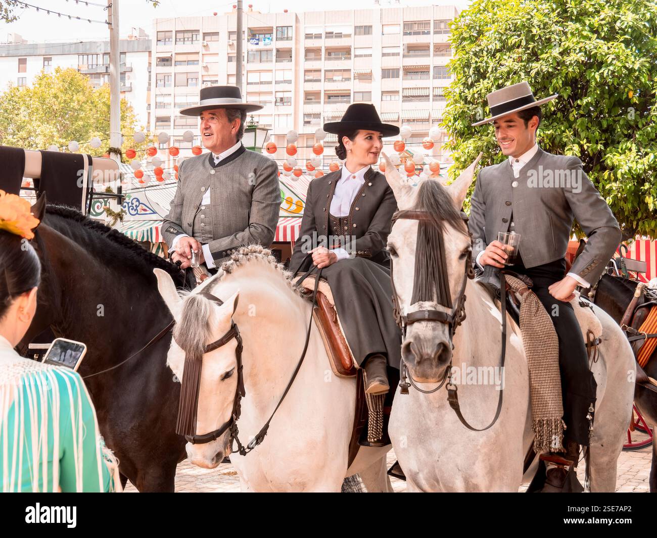 Group of Spanish riders in traditional attire on horseback at an ...