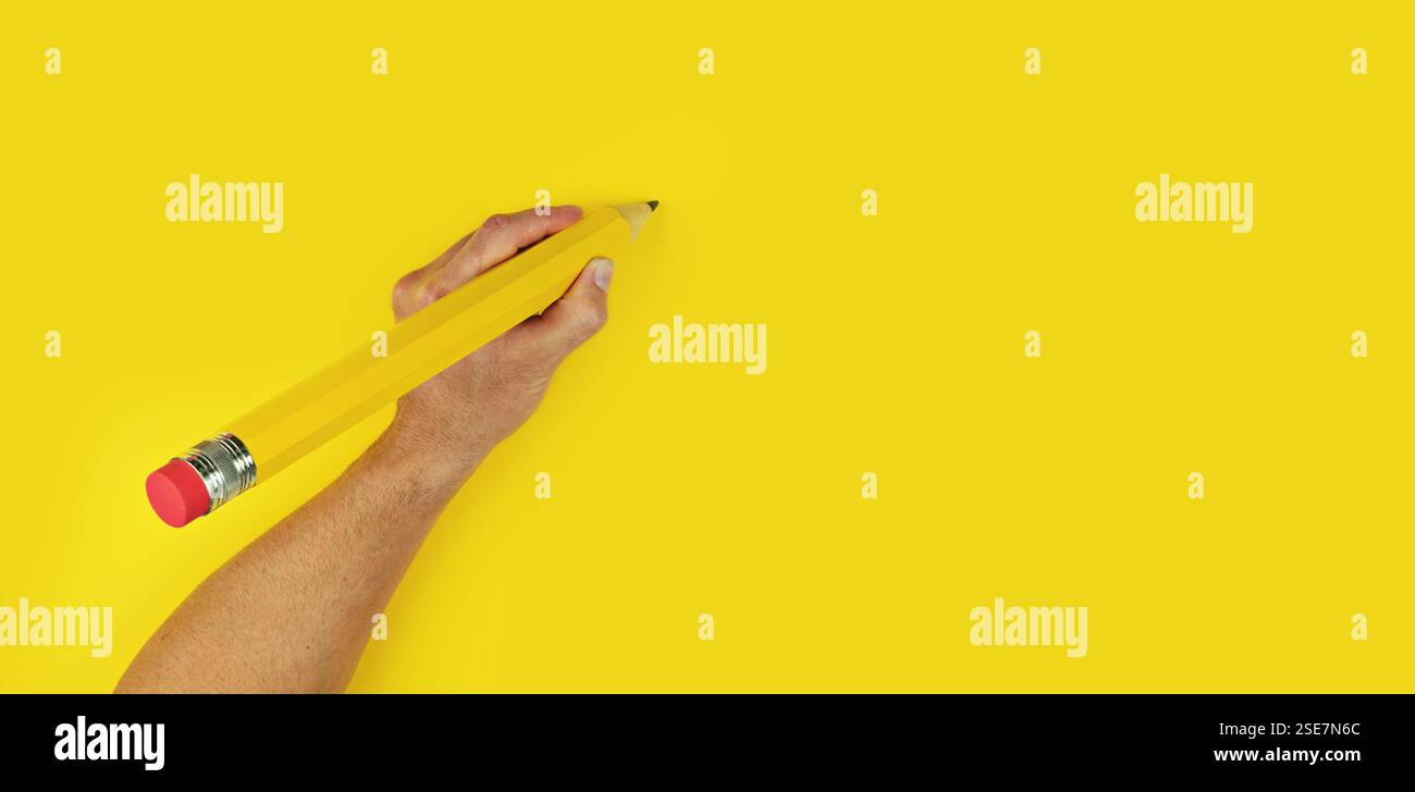 Yellow big pencil in left hand on bright yellow background with copy ...