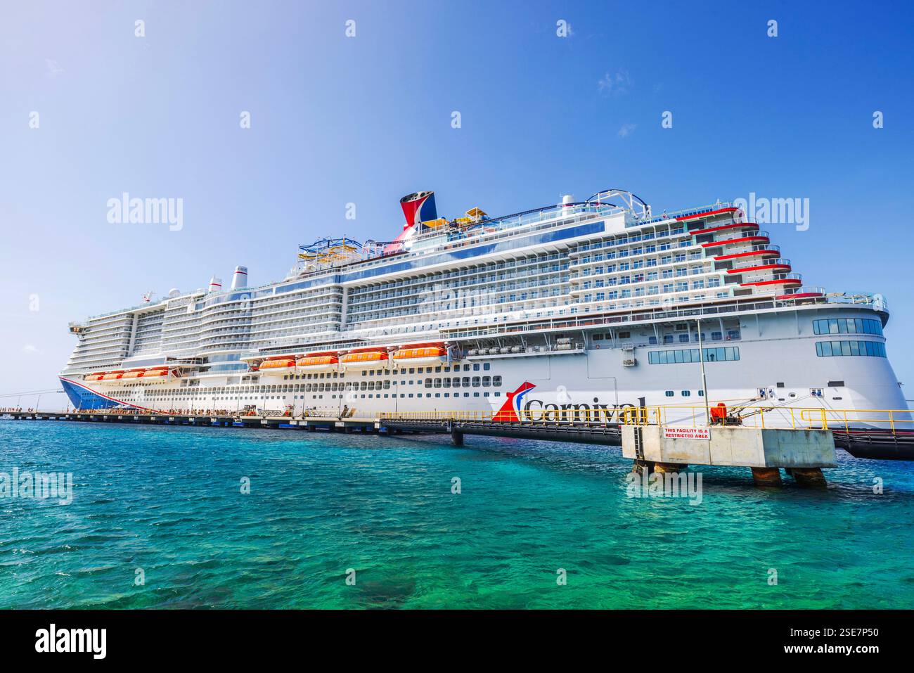 Carnival cruise ship docked in turquoise water Caribbean sea under ...