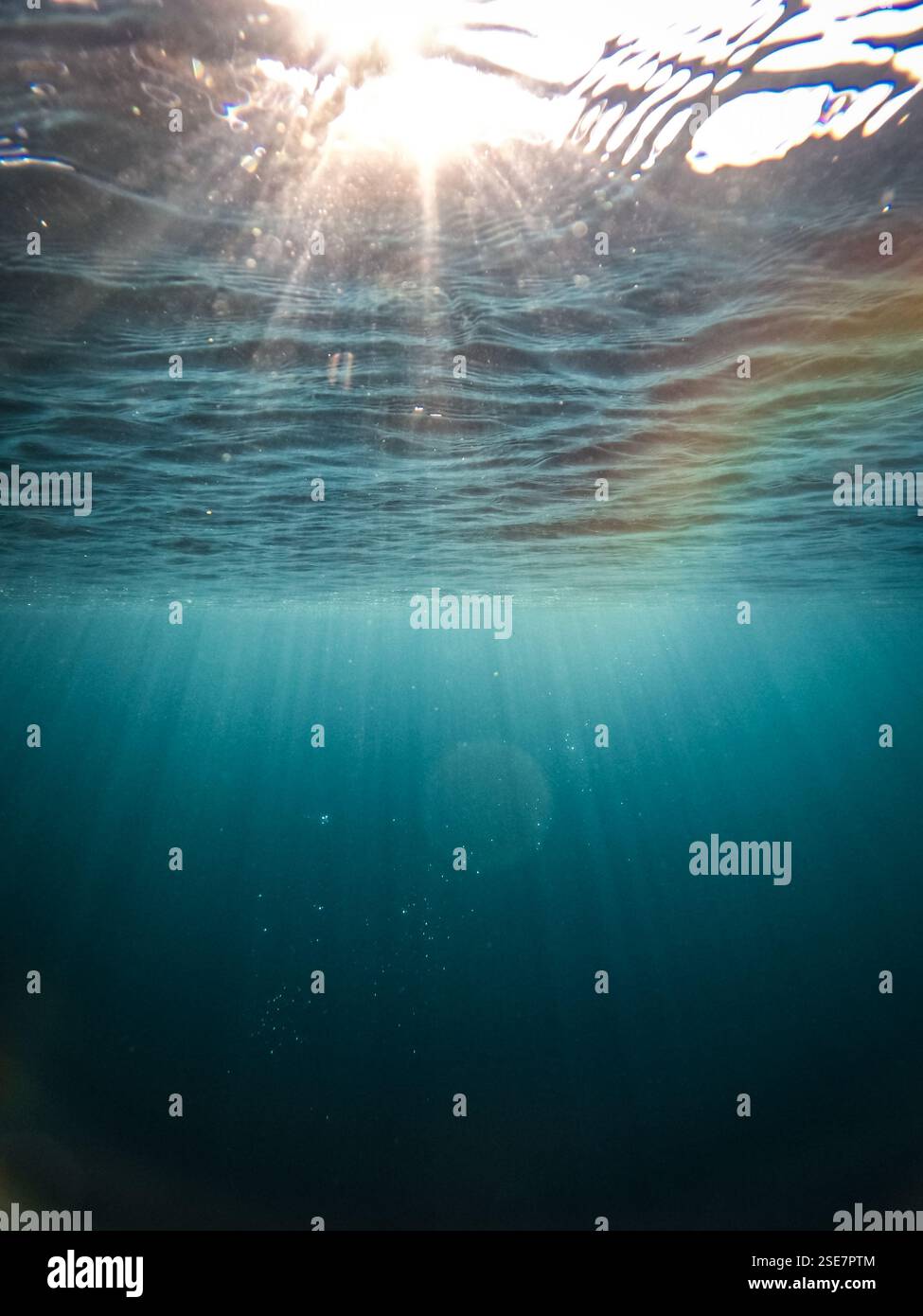 Deep blue underwater background with sunrays, rainbow flares and ...