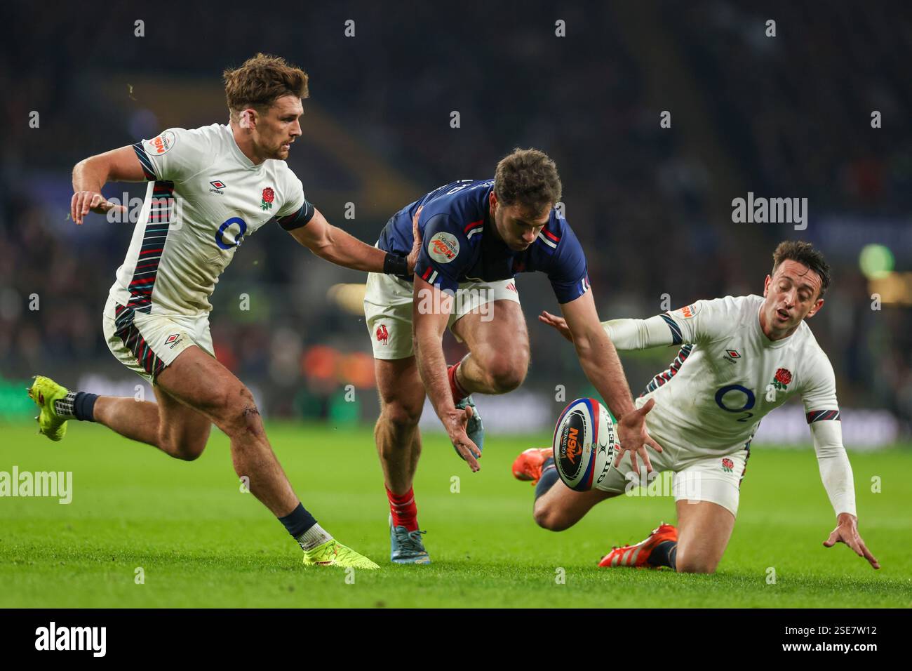 France's Damian Penaud, center, drops the ball challenged by England's ...
