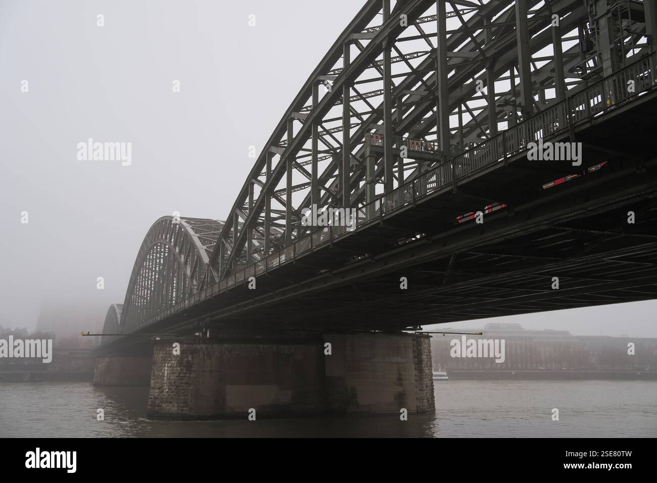 A foggy day reveals the intricate iron design of a historic bridge ...