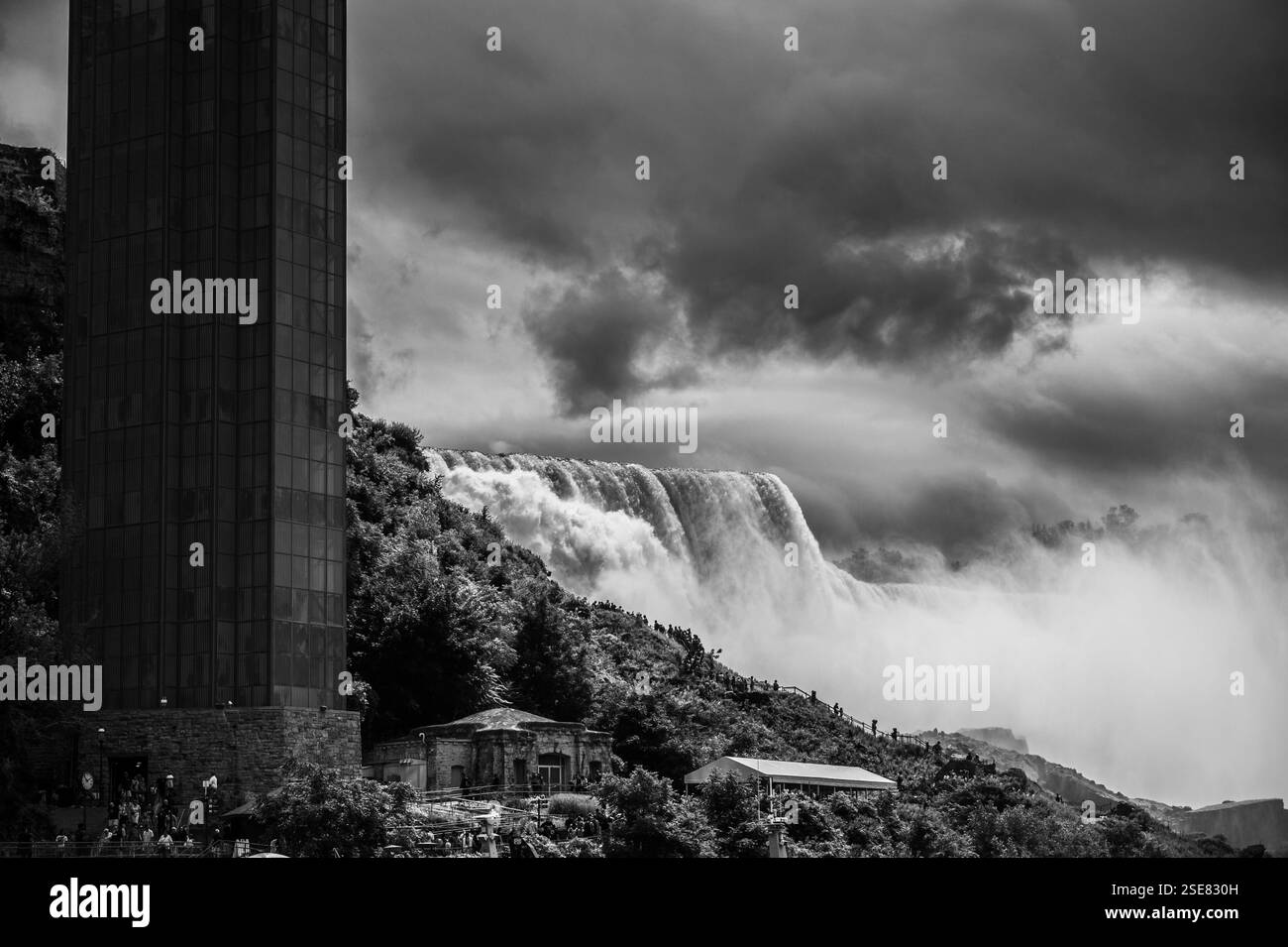 A dramatic waterfall crashes down with great force, surrounded by lush ...