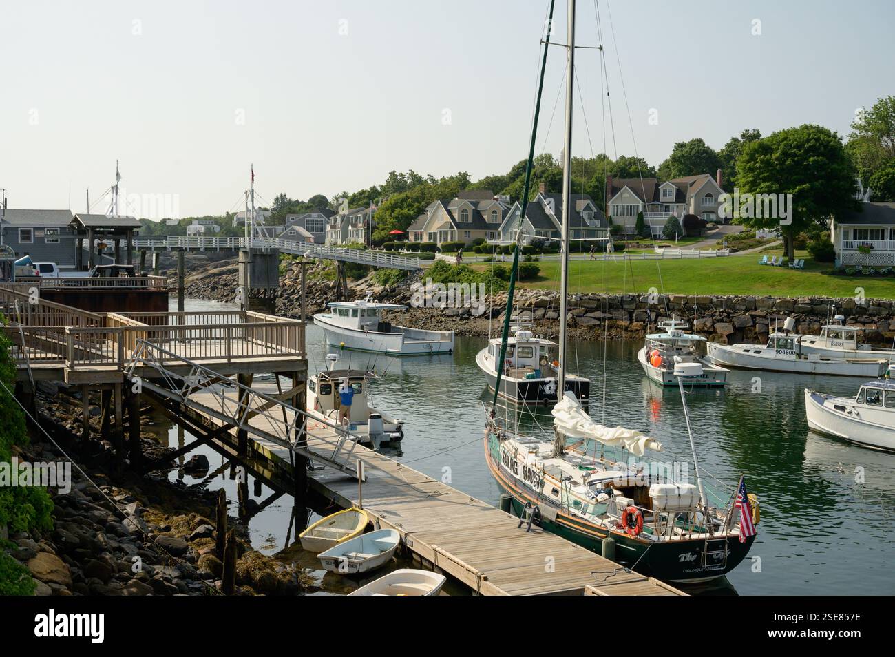A peaceful harbor showcases multiple sailboats and fishing vessels ...