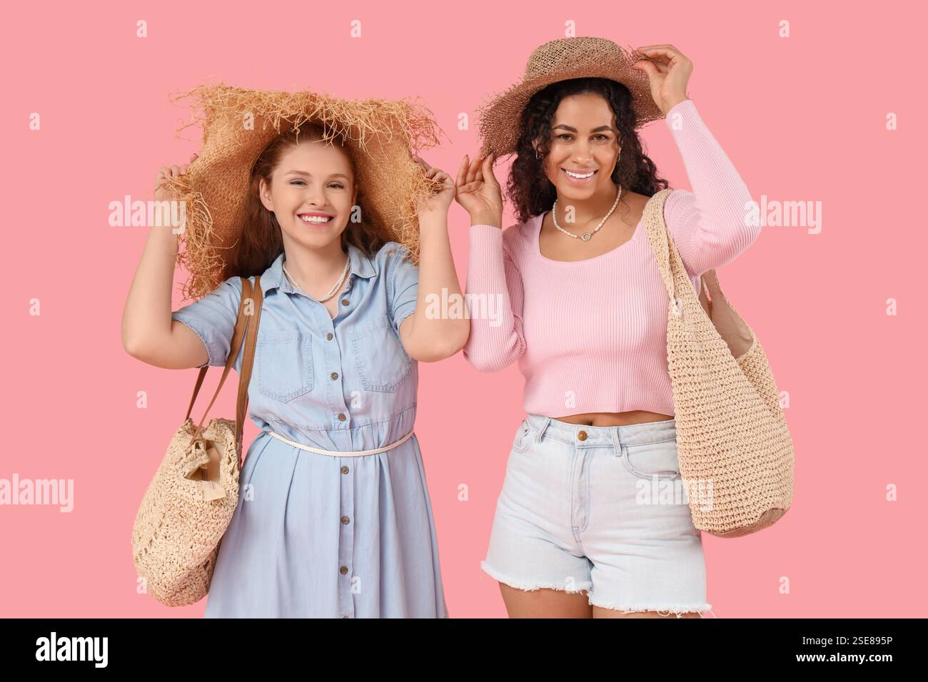 Beautiful young happy female friends in wicker hats with summer bags on ...